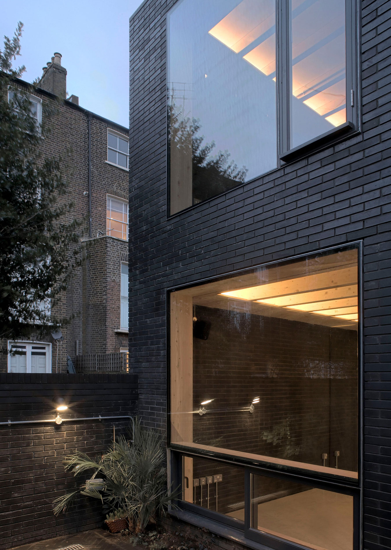 A Fascinating Home with Black Engineering Bricks and Slabs of White ...