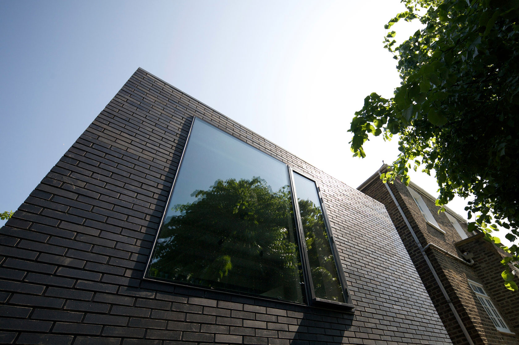 A Fascinating Home with Black Engineering Bricks and Slabs of White ...