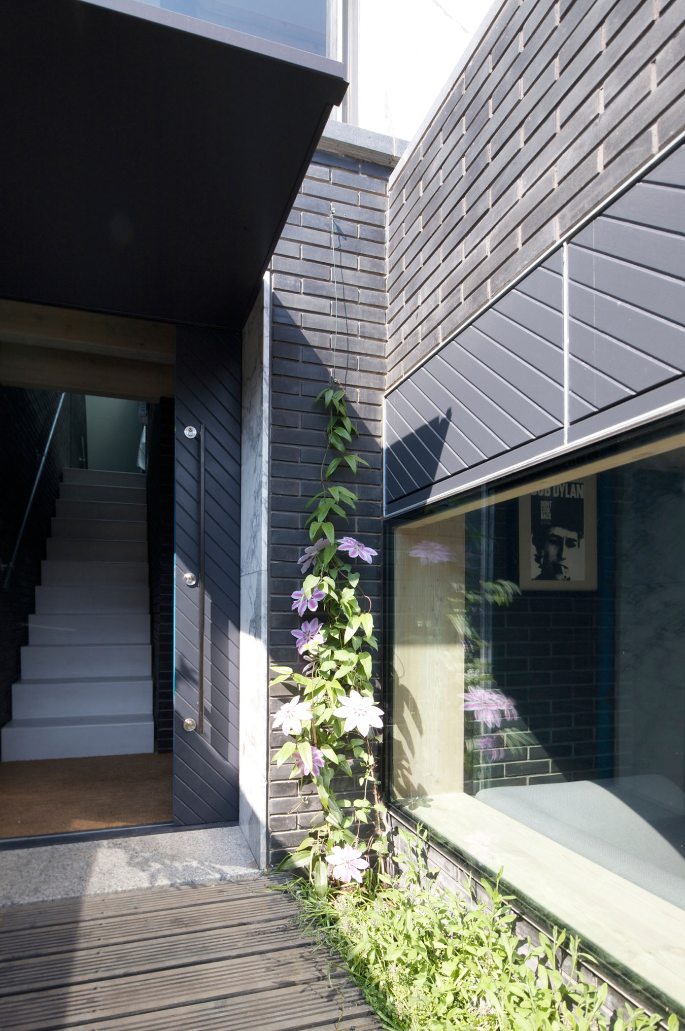 A Fascinating Home with Black Engineering Bricks and Slabs of White ...