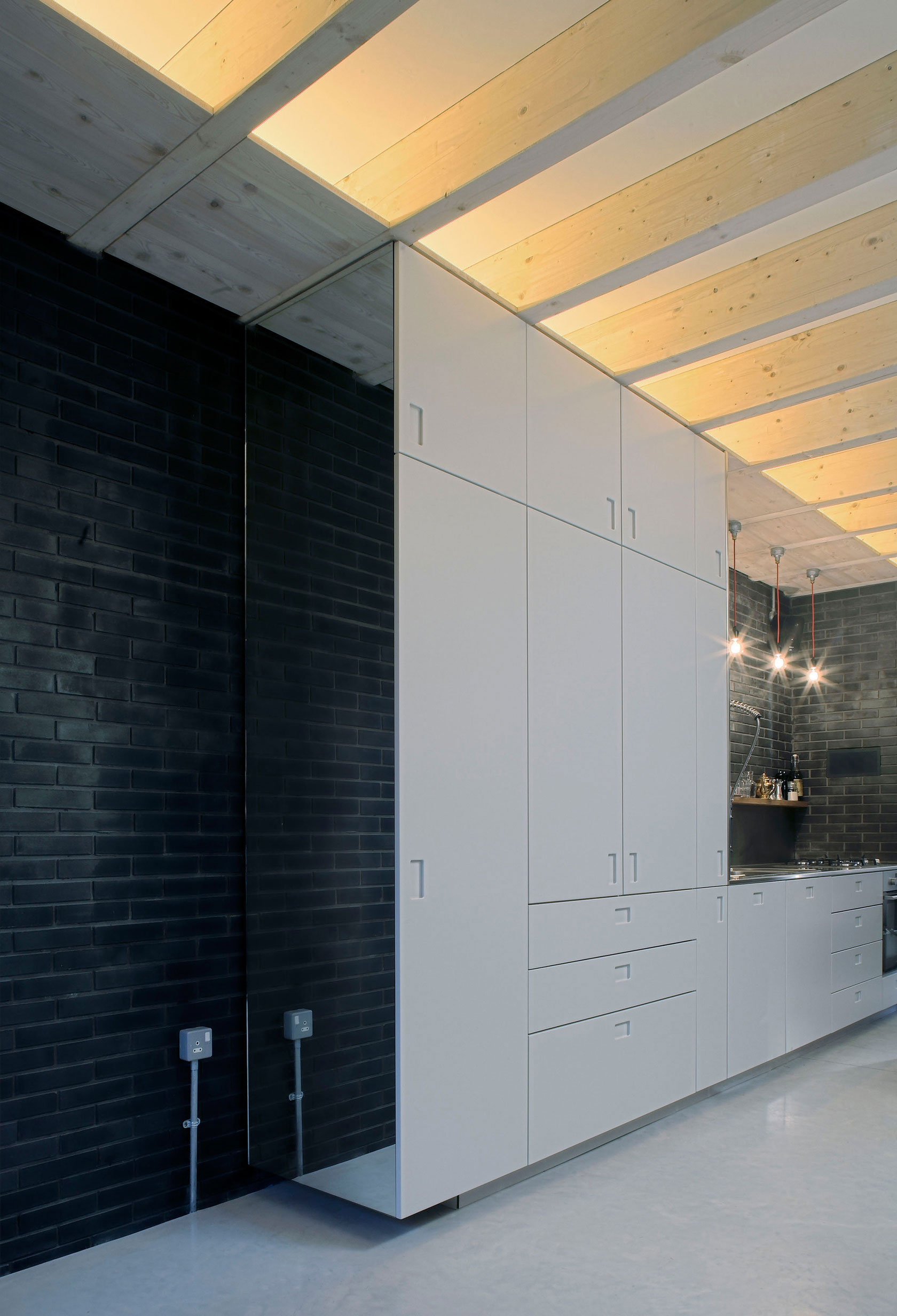 A Fascinating Home with Black Engineering Bricks and Slabs of White ...